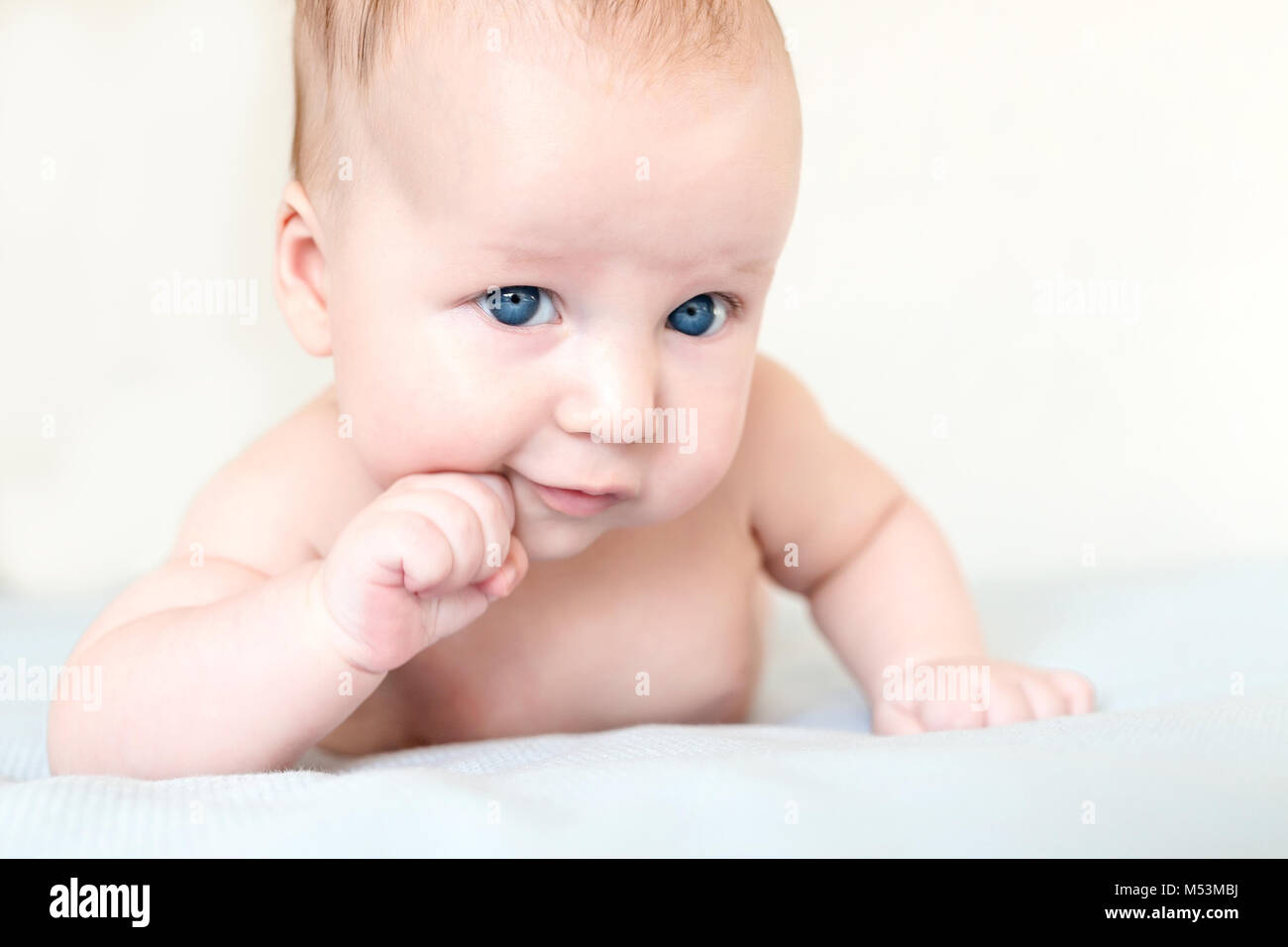 Portrait of small infant kid boy. Child holding head with fist. Baby ...