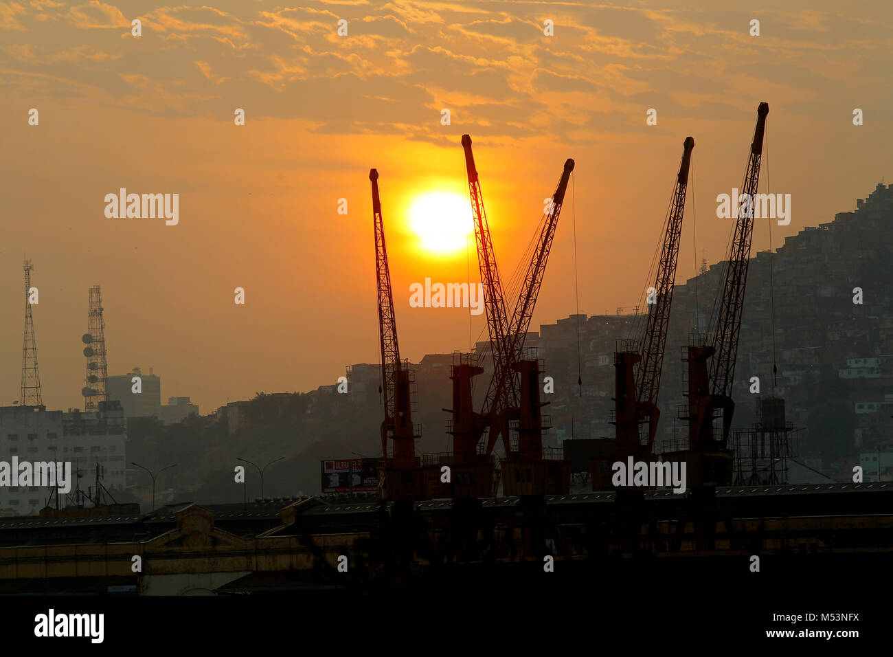 Sunrise at Rio de Janeiro Port with cranes silhoetted against the sun ...