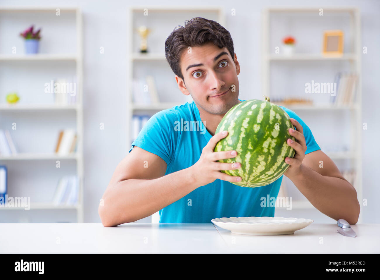 Man eating watermelon at home Stock Photo - Alamy