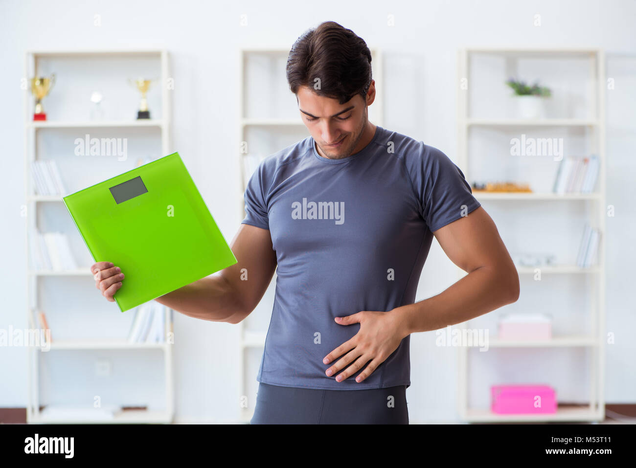 Man with scales in sports and health concept Stock Photo - Alamy