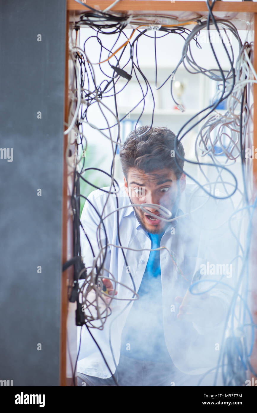 Electrician trying to untangle wires in repair concept Stock Photo - Alamy