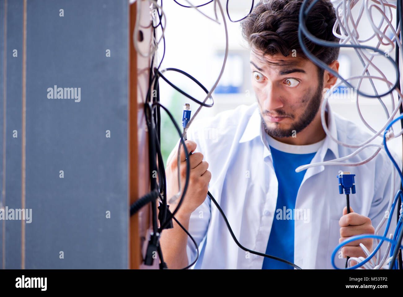 Electrician trying to untangle wires in repair concept Stock Photo - Alamy