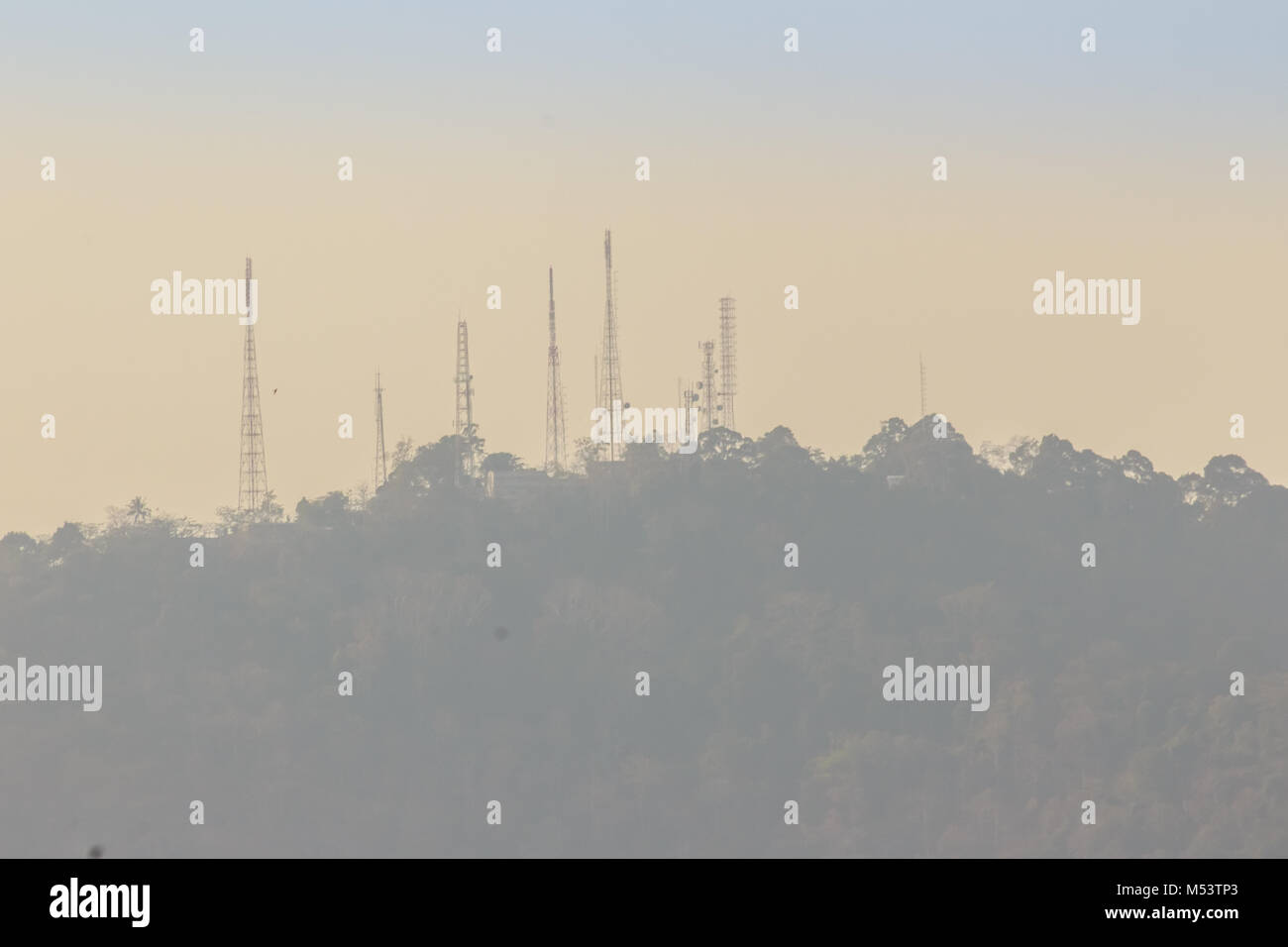 Telecommunication towers on the summit of the hill under cloudy blue ...