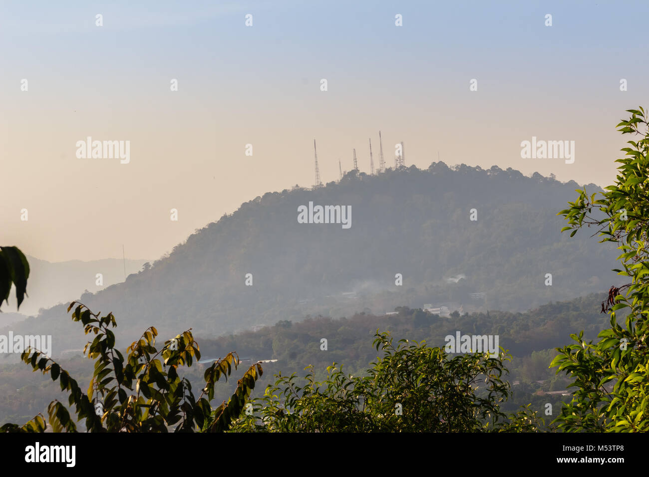 Telecommunication towers on the summit of the hill under cloudy blue ...