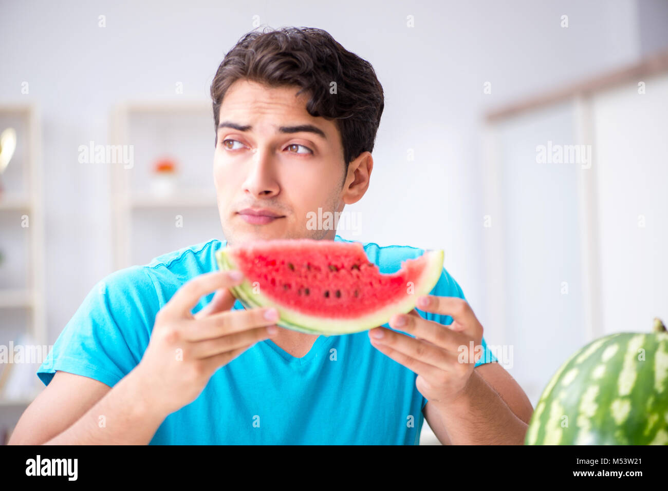 Man eating watermelon at home Stock Photo - Alamy