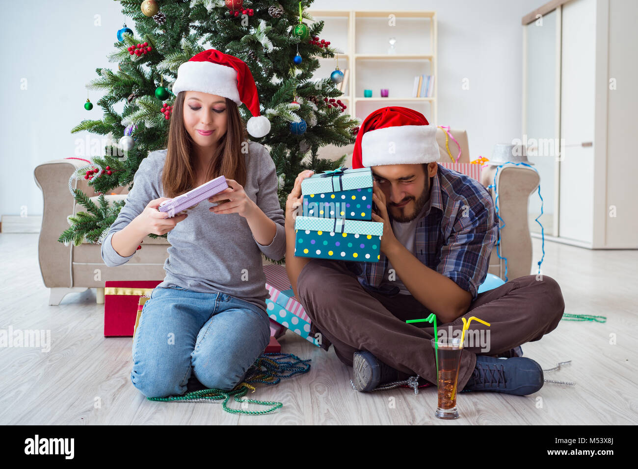 Girlfriend and boyfriend opening christmas gifts Stock Photo - Alamy
