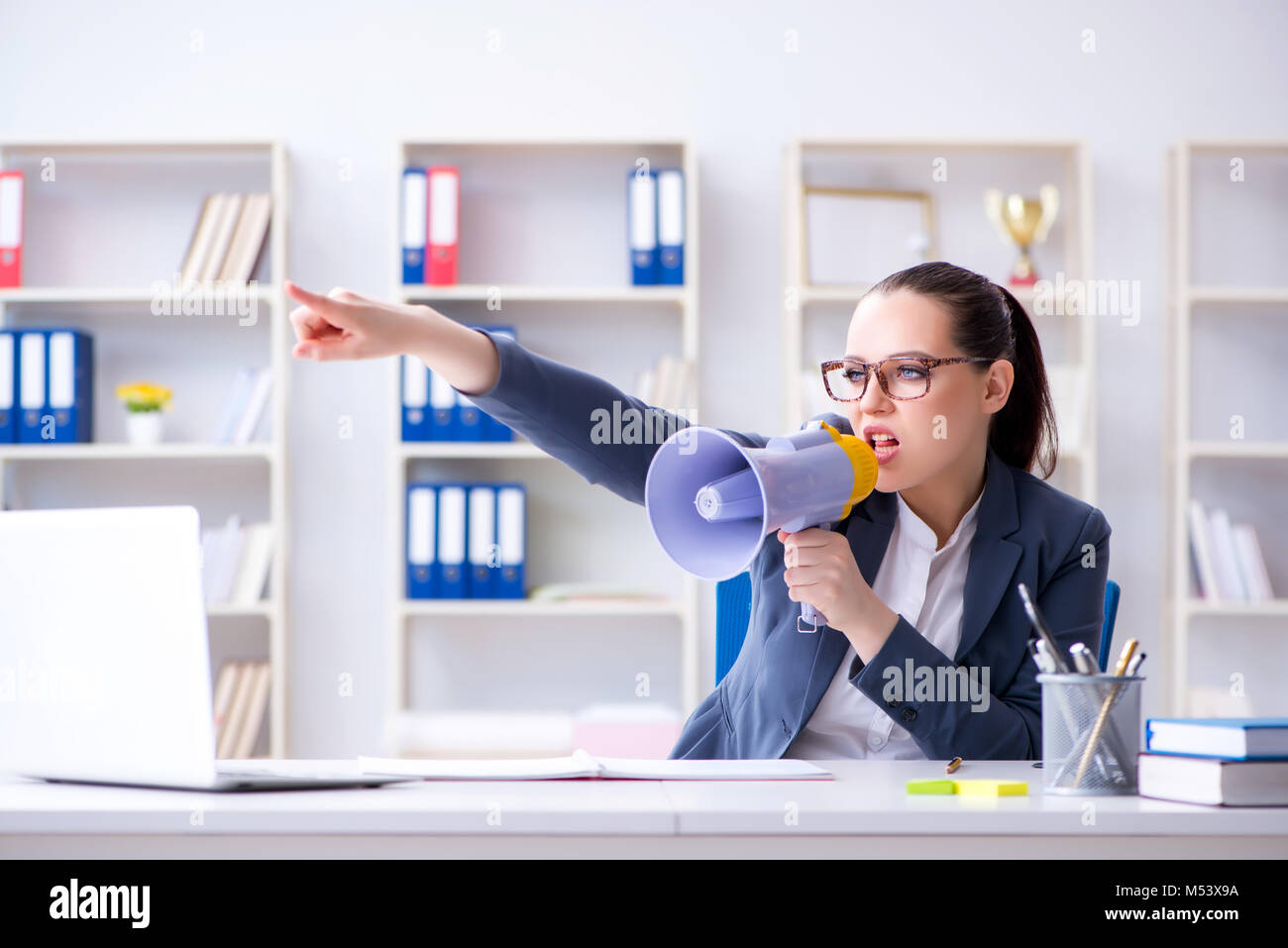 Angry businesswoman yelling with loudspeaker in office Stock Photo - Alamy
