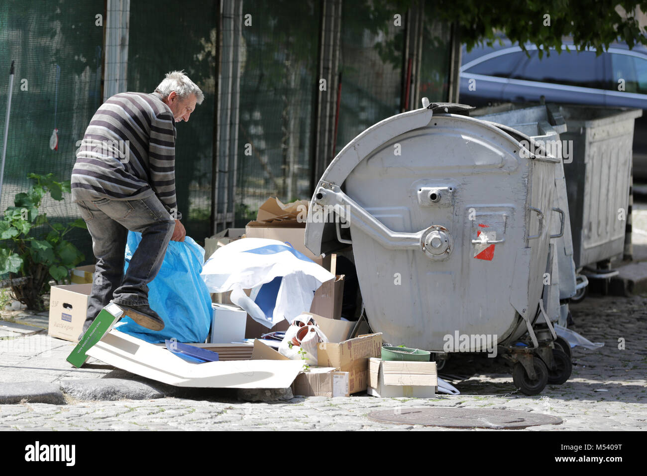Poor homeless man collecting paper Stock Photo - Alamy