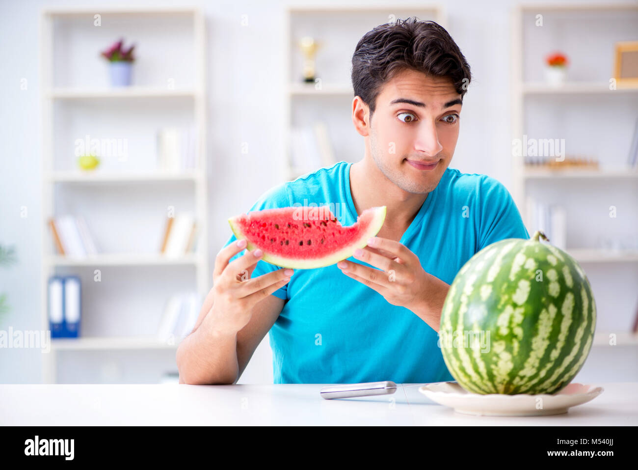 Man eating watermelon at home Stock Photo - Alamy