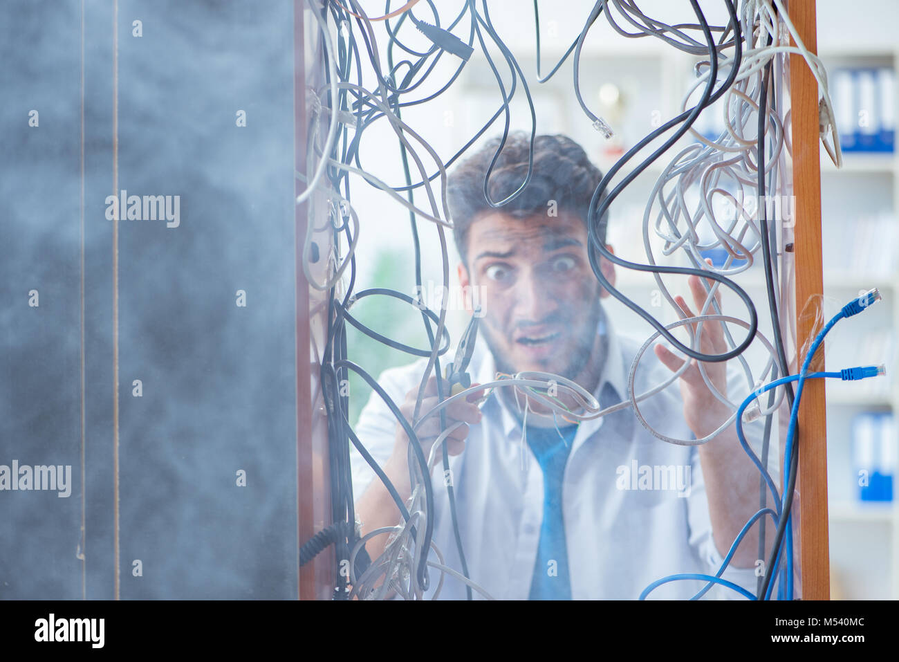 Electrician trying to untangle wires in repair concept Stock Photo - Alamy