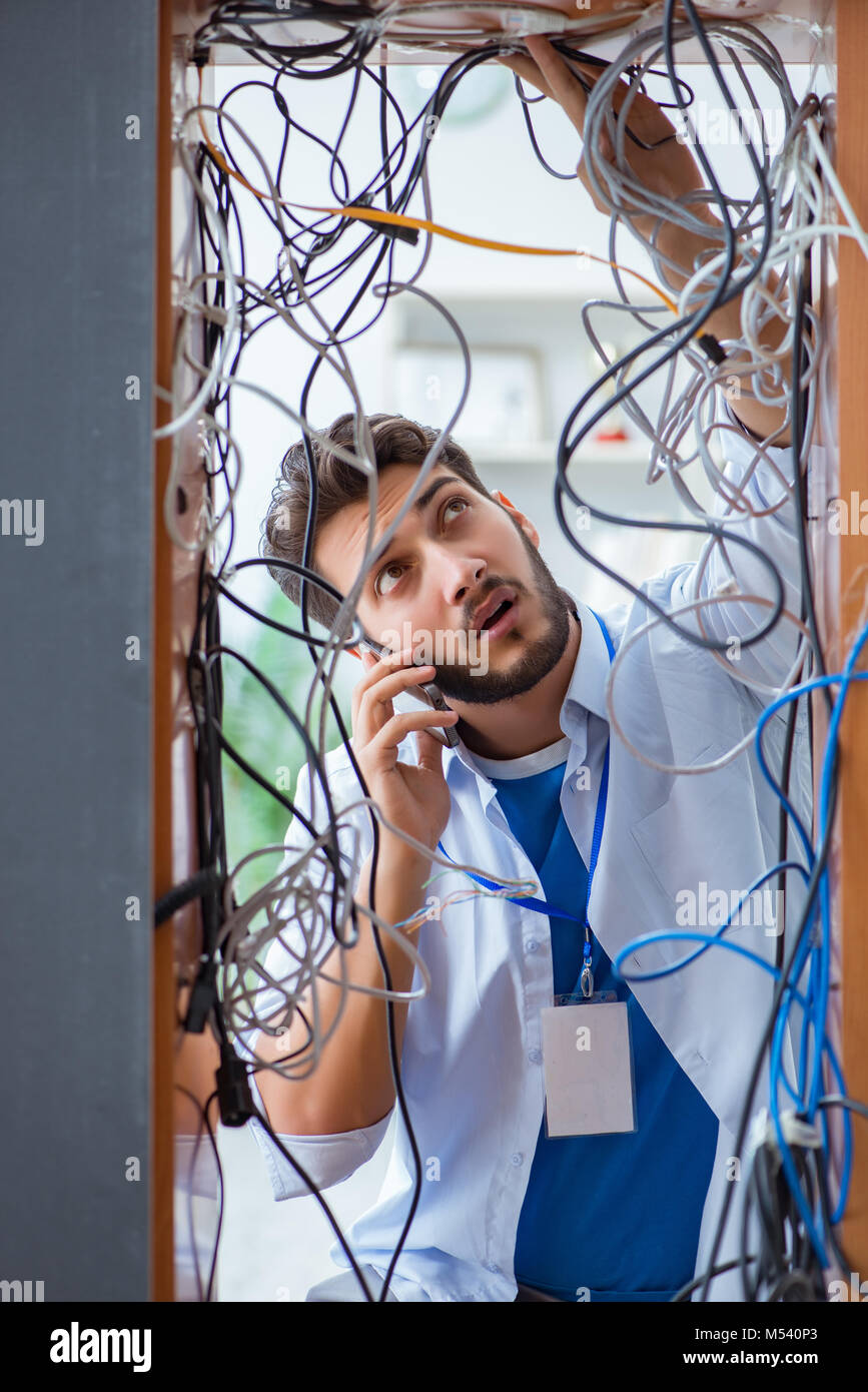 Electrician trying to untangle wires in repair concept Stock Photo - Alamy