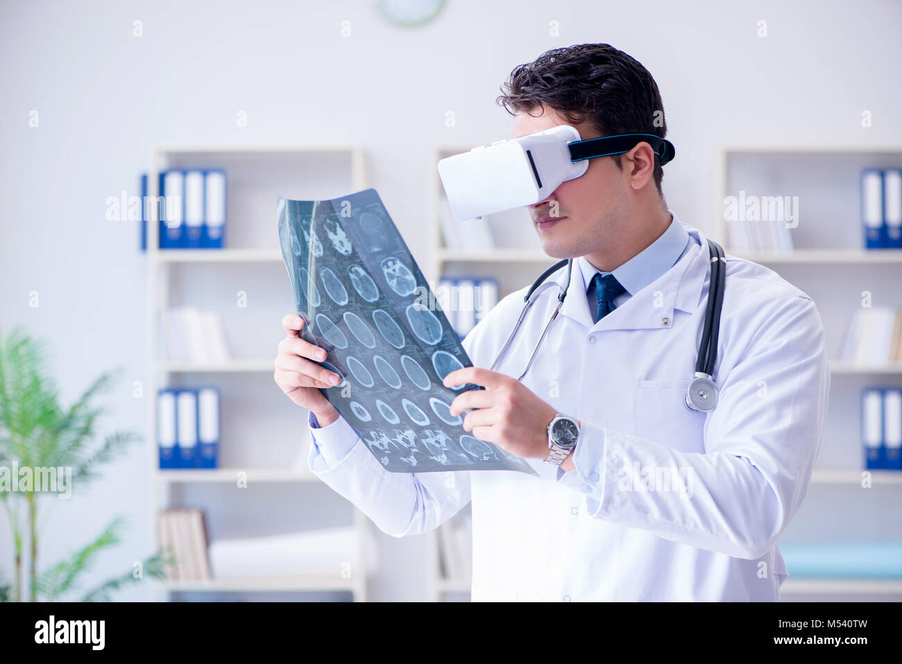 Young doctor looking at MRI scan through VR glasses Stock Photo - Alamy
