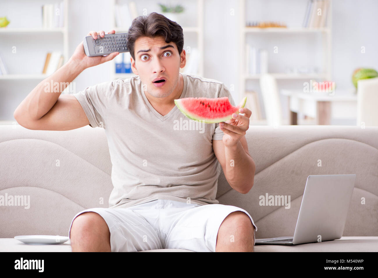 Man eating watermelon at home Stock Photo - Alamy