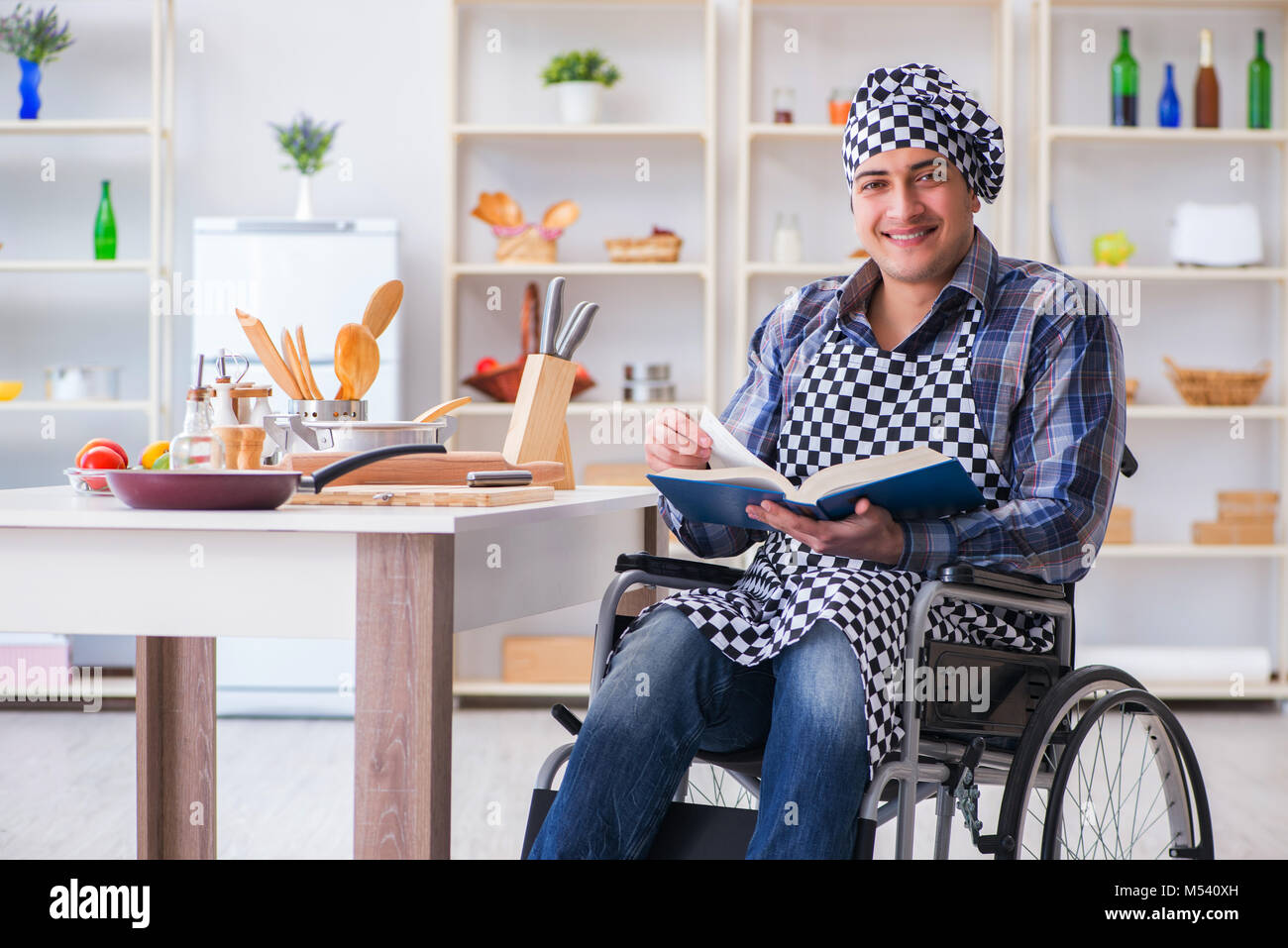 Young man cook with book of food recipes Stock Photo - Alamy
