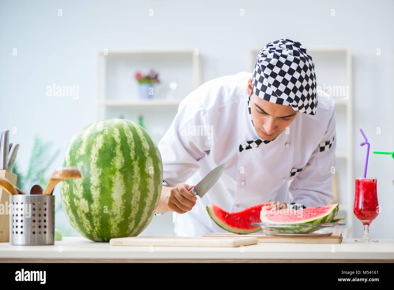 Male cook with watermelon in kitchen Stock Photo - Alamy