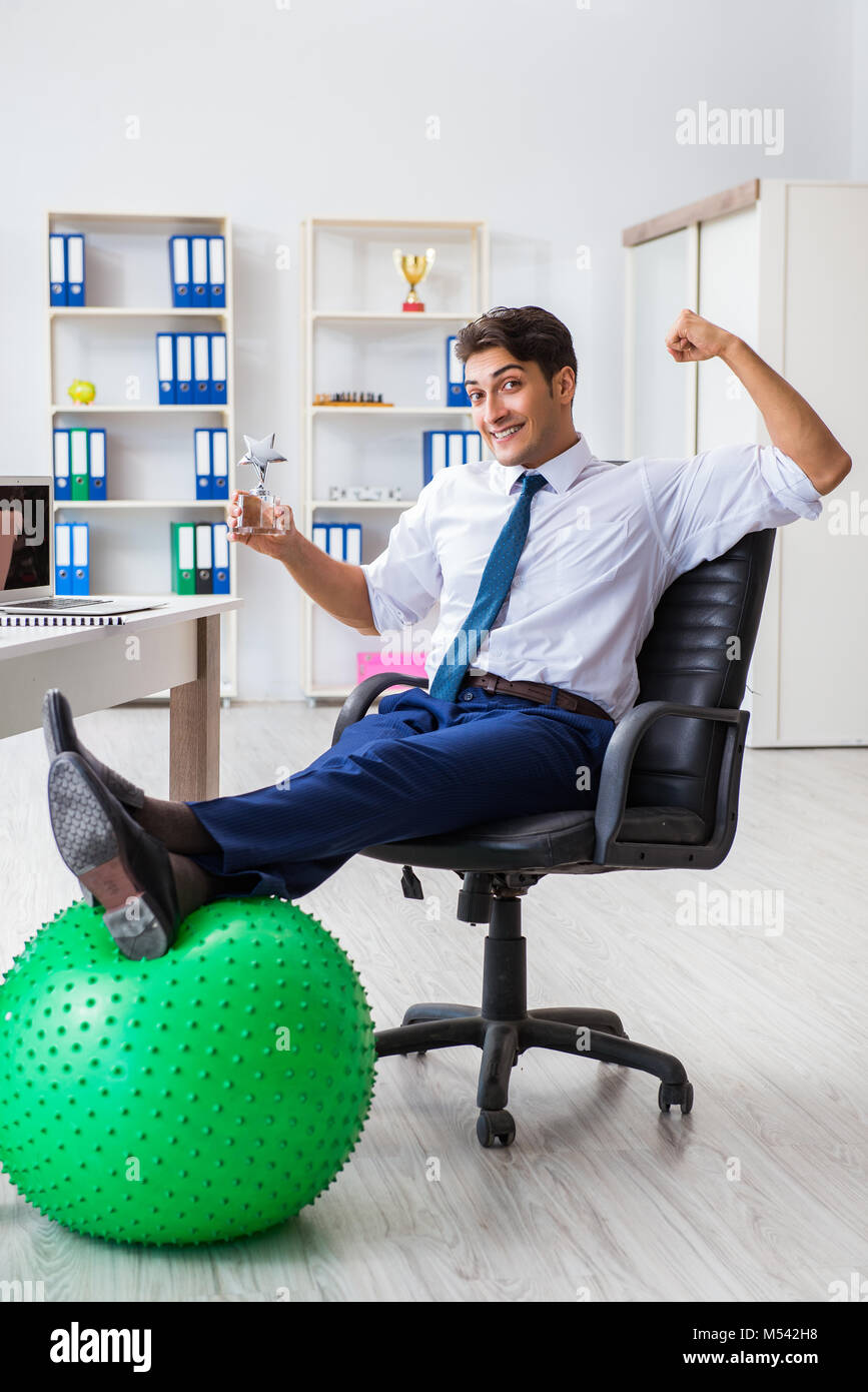 Young businessman doing sports stretching at workplace Stock Photo - Alamy