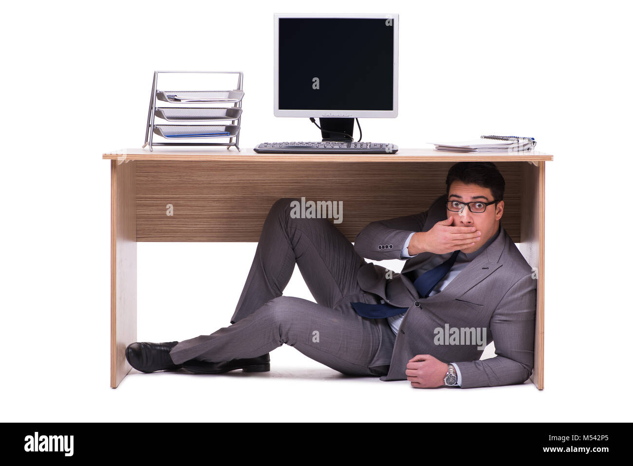 Person hiding under desk Cut Out Stock Images & Pictures - Alamy