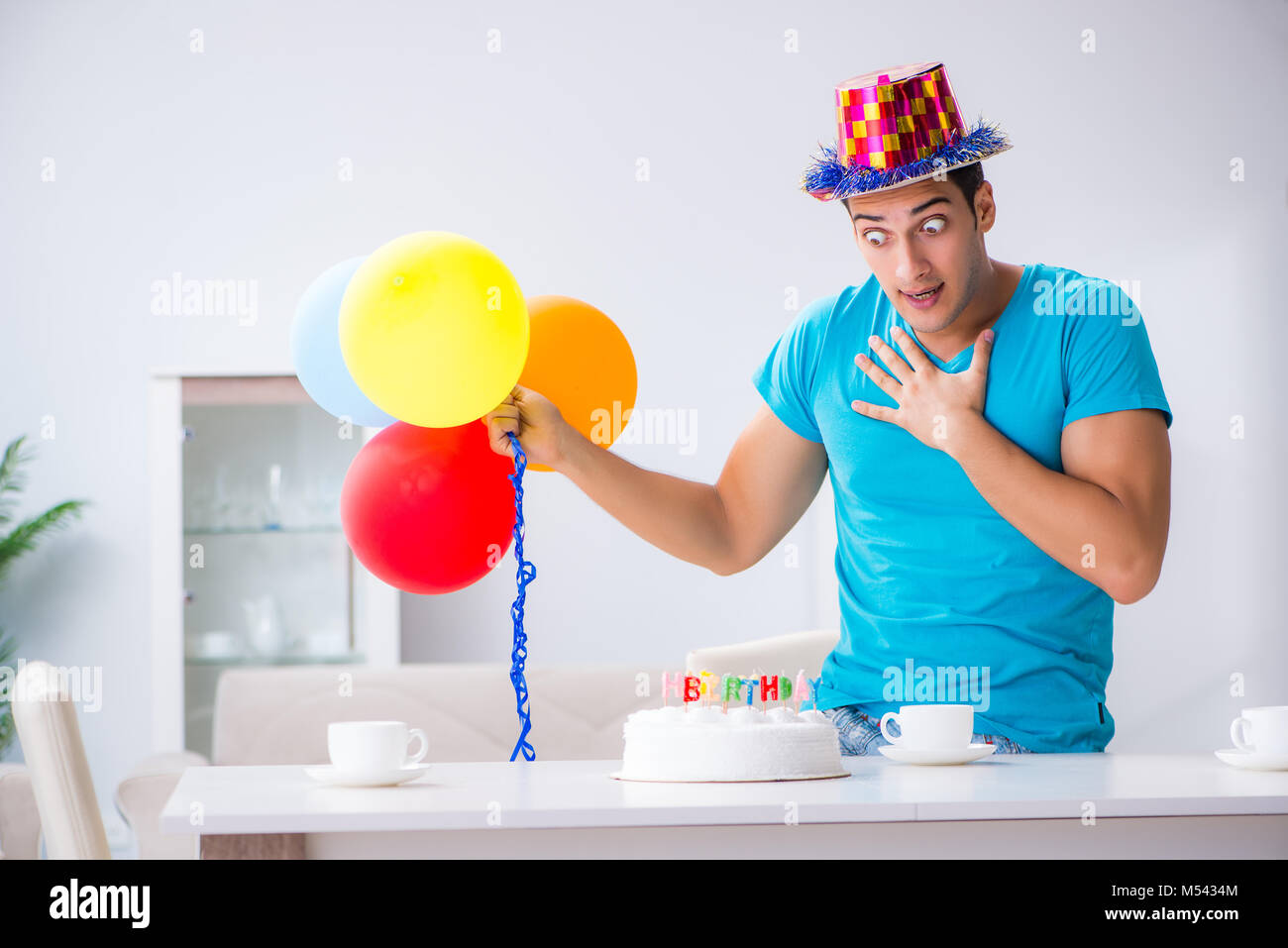 Young man celebrating birthday alone at home Stock Photo - Alamy