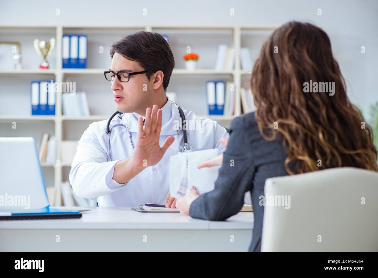 Young doctor in medical insurance fraud concept Stock Photo - Alamy