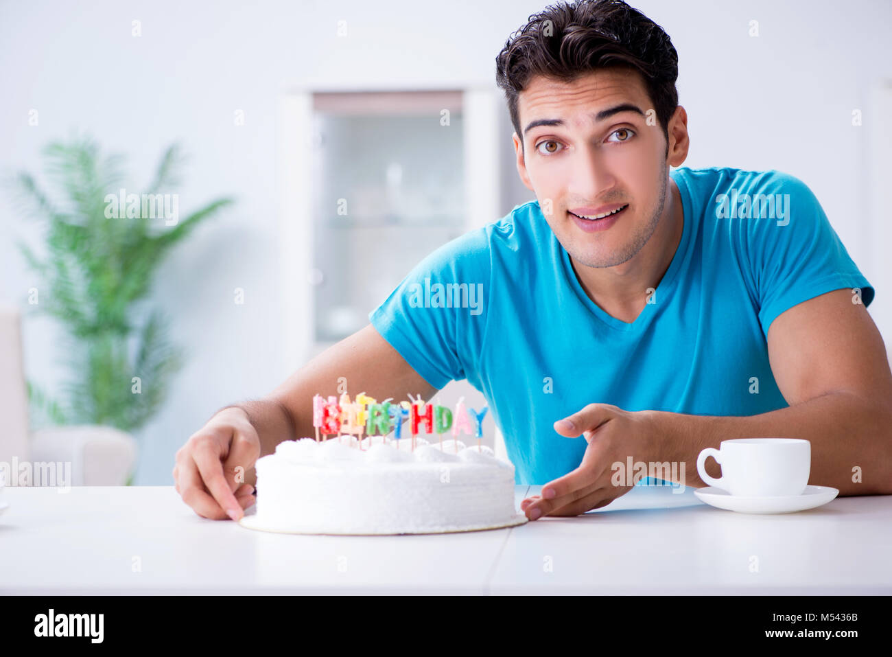 Young man celebrating birthday alone at home Stock Photo - Alamy