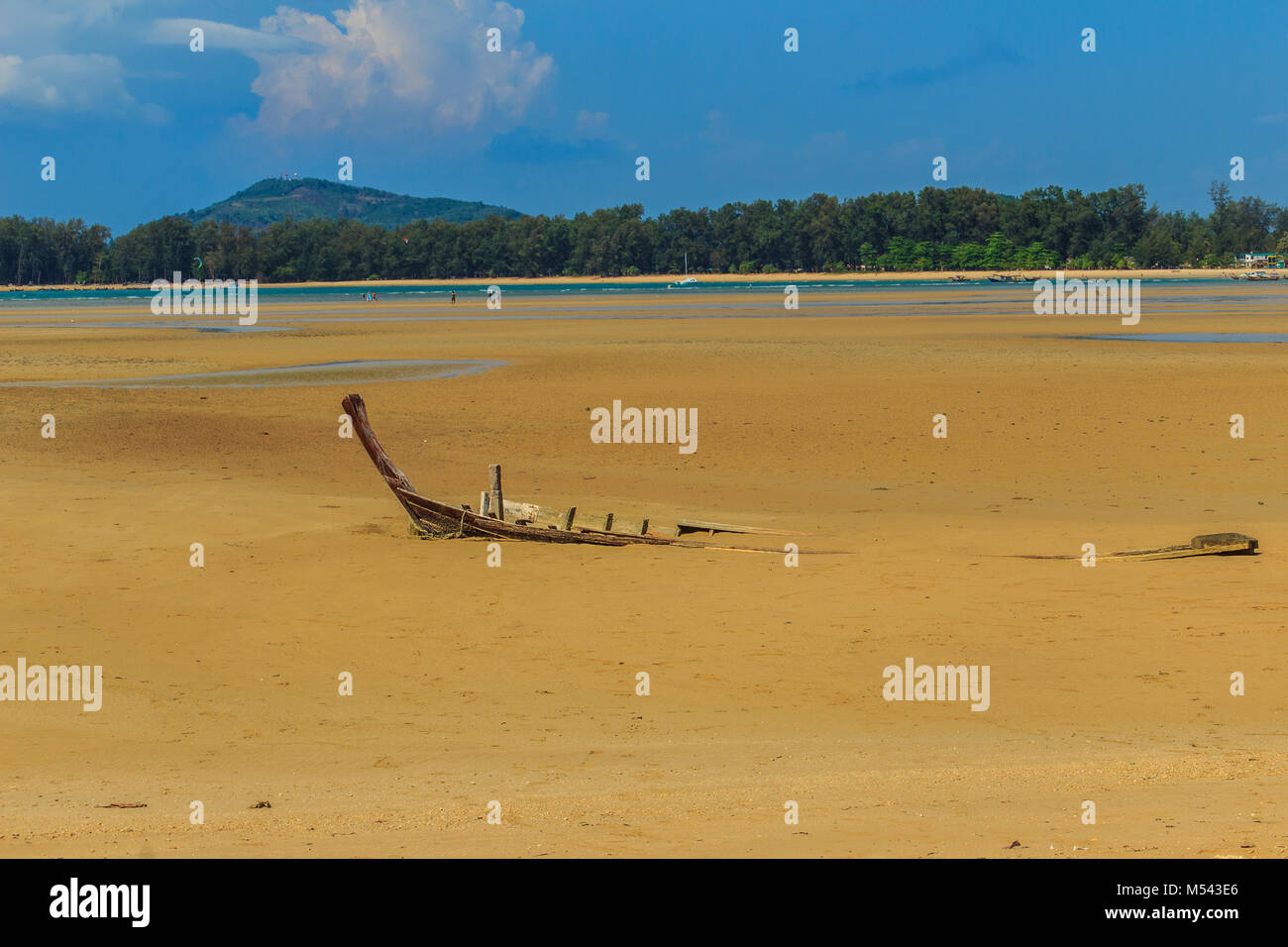 Old wreck fishing boat buried in the sand with blue sky on cloudy day ...