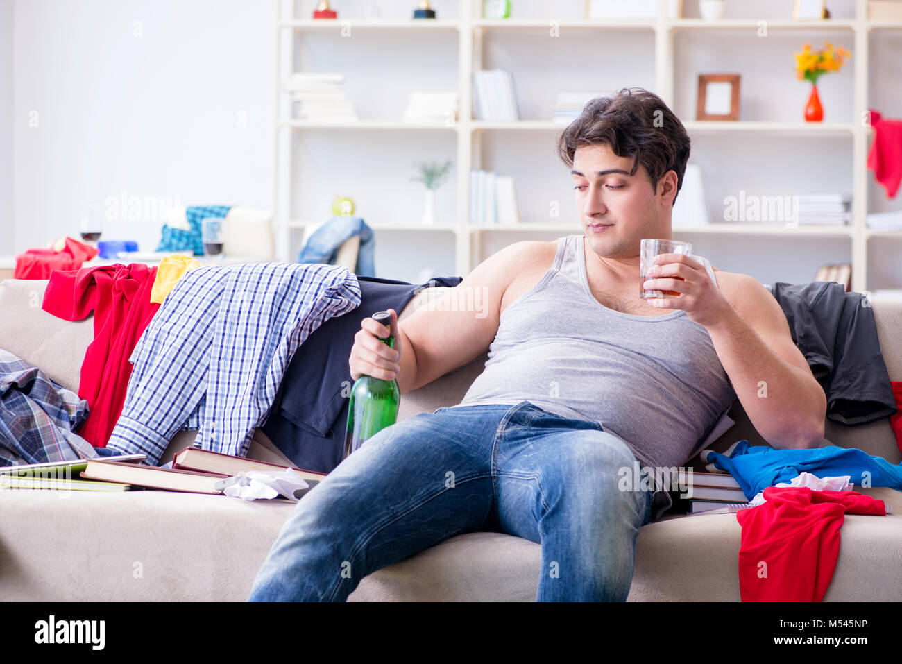Young man student drunk drinking alcohol in a messy room Stock Photo ...
