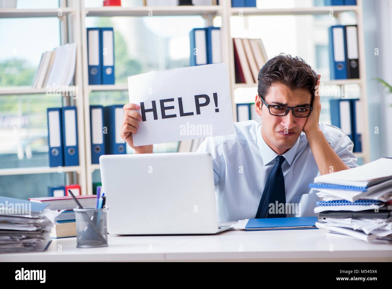 Young businessman asking for help in office Stock Photo - Alamy