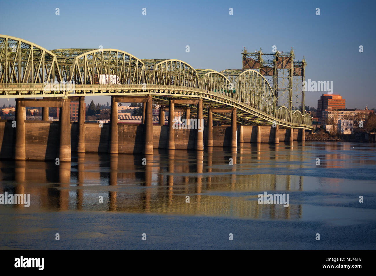 A golden hour image of the I5 bridge reflecting in the calm water ...