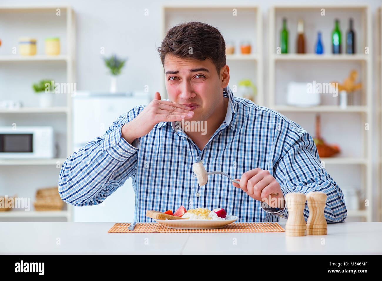 Man eating tasteless food at home for lunch Stock Photo - Alamy