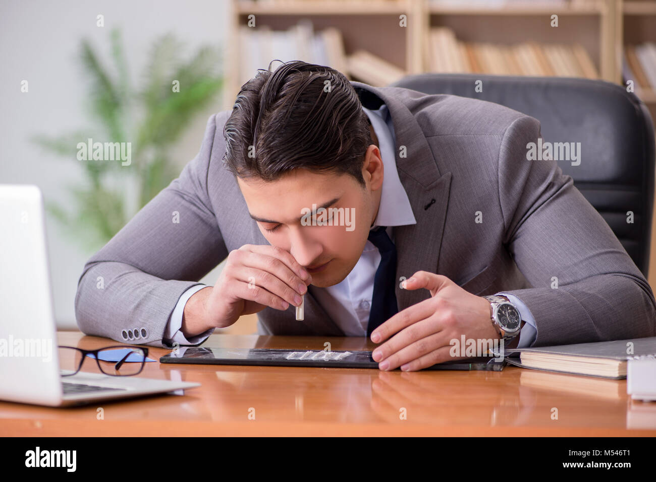 Drug addict businessman in the office Stock Photo - Alamy