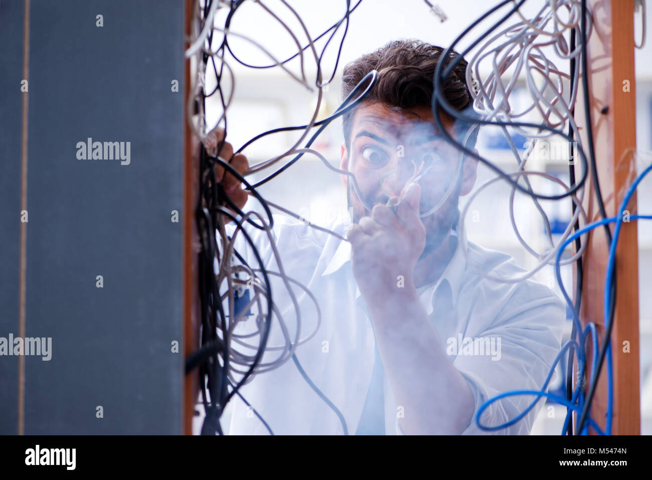 Electrician trying to untangle wires in repair concept Stock Photo - Alamy