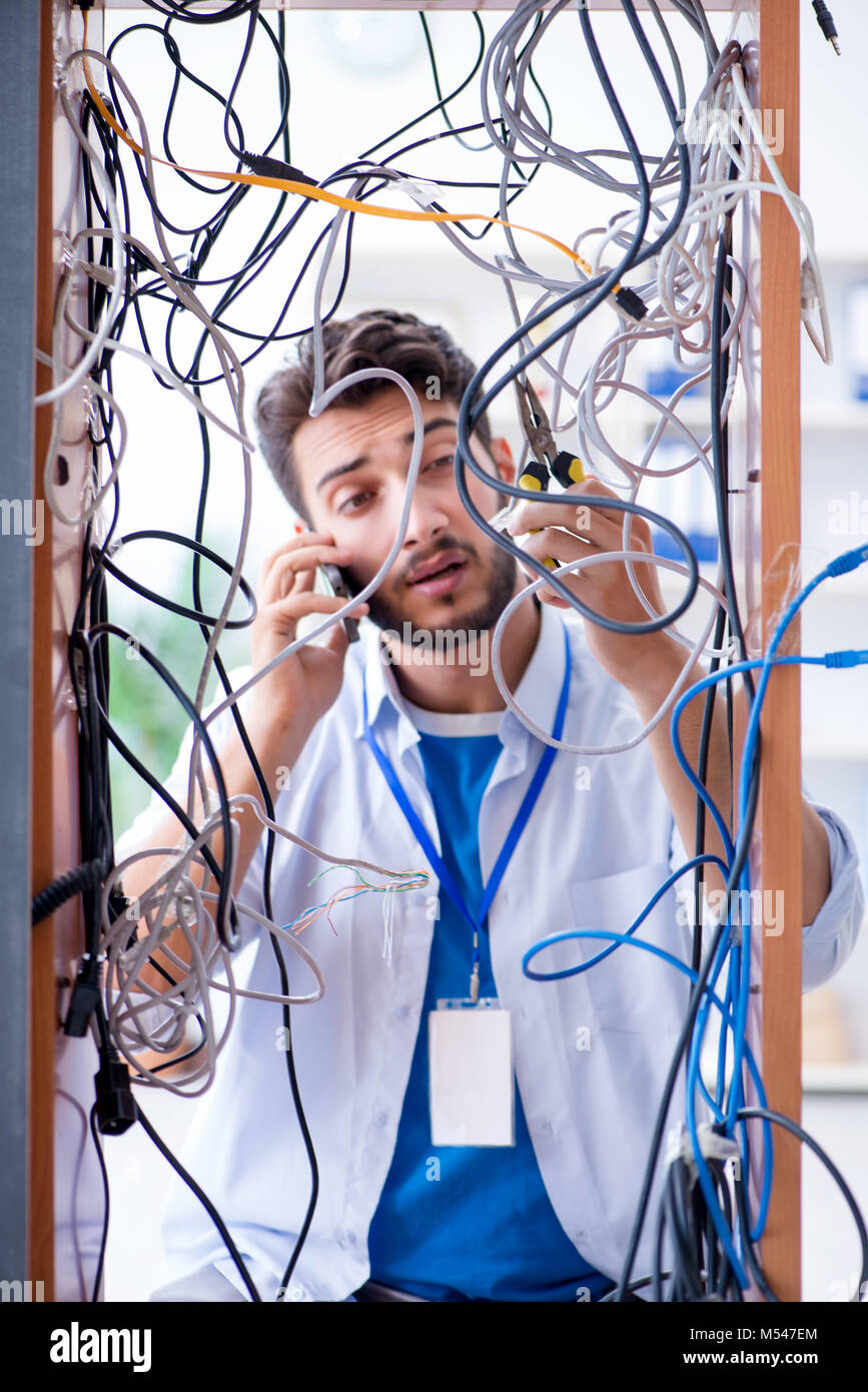 Electrician trying to untangle wires in repair concept Stock Photo - Alamy