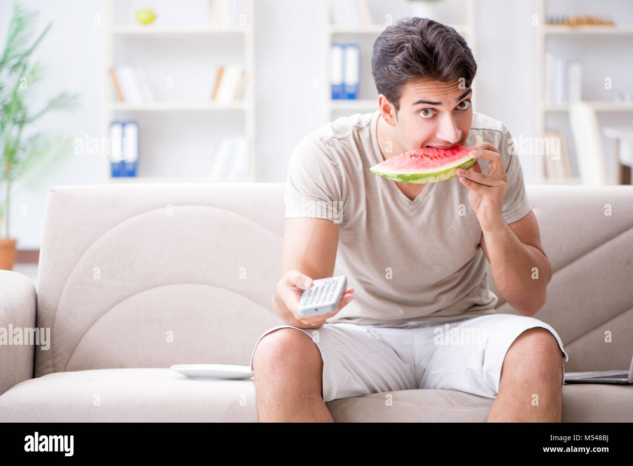 Man eating watermelon at home Stock Photo - Alamy