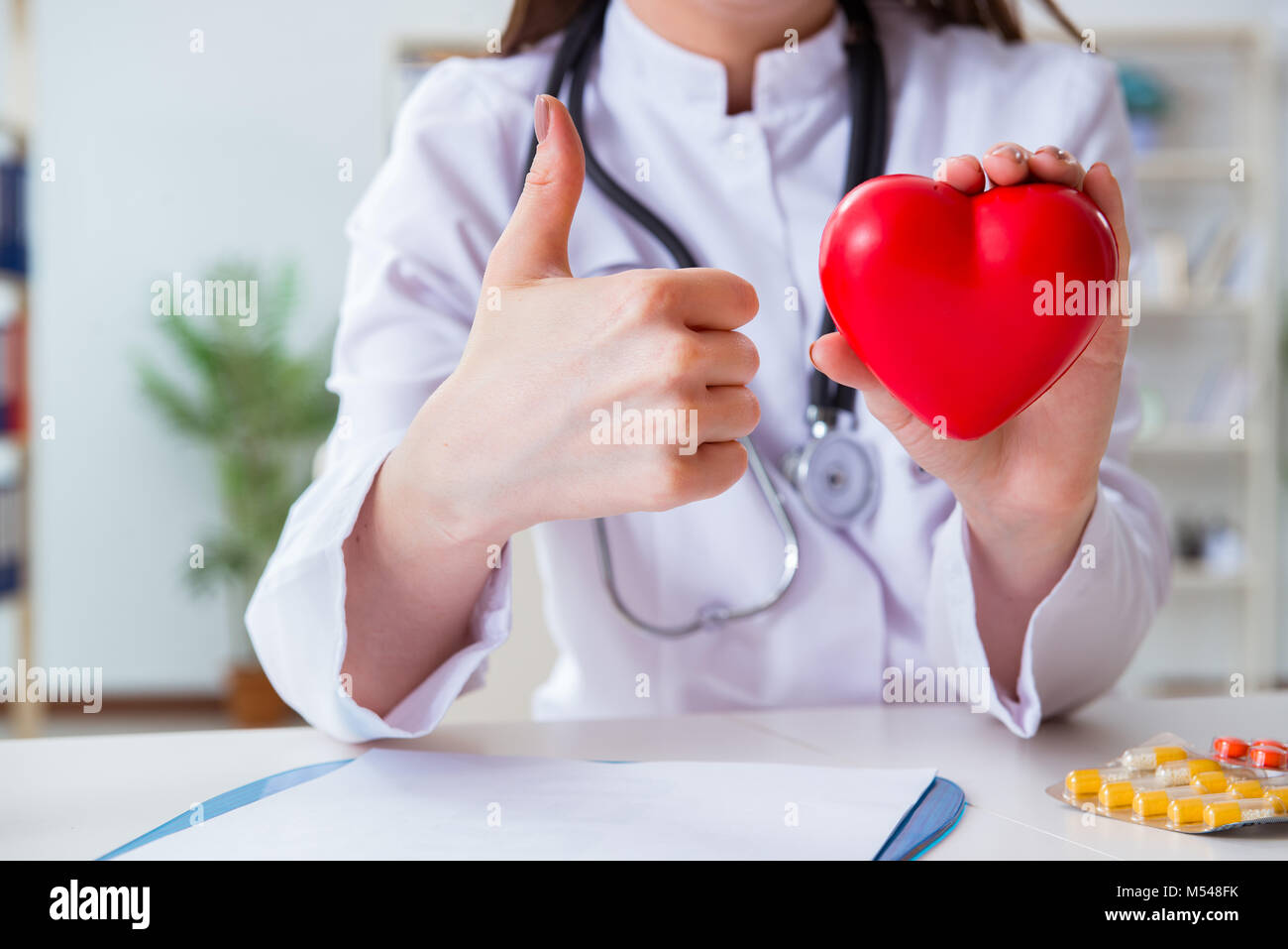Doctor cardiologist with red heart in the hospital Stock Photo - Alamy