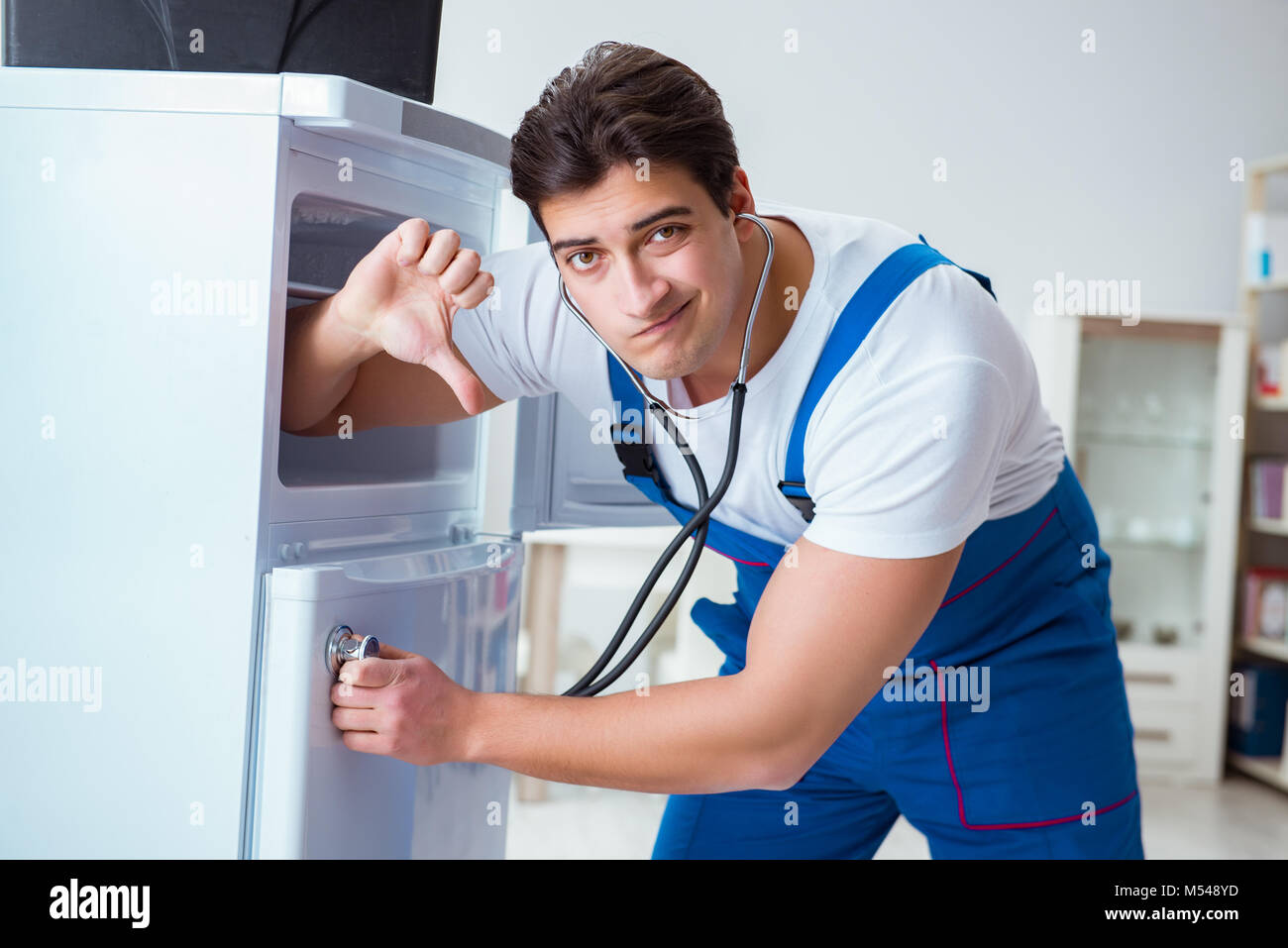 Repairman contractor repairing fridge in DIY concept Stock Photo - Alamy