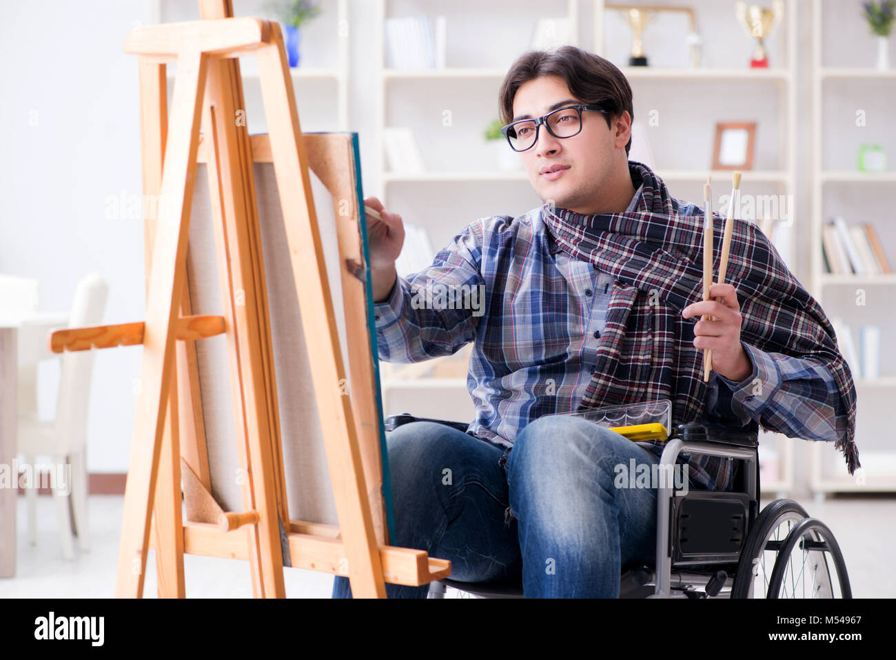 Disabled artist painting picture in studio Stock Photo - Alamy