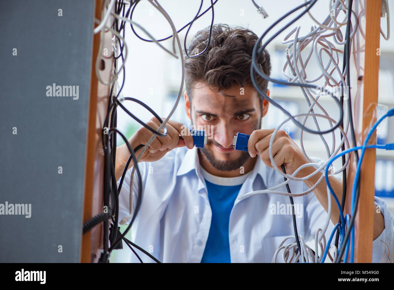 Electrician trying to untangle wires in repair concept Stock Photo - Alamy