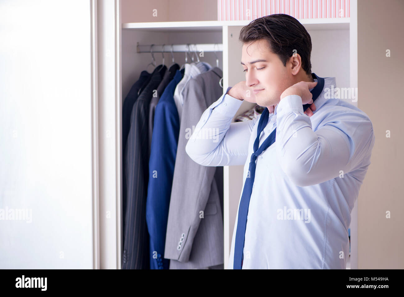 Young man businessman getting dressed for work Stock Photo - Alamy