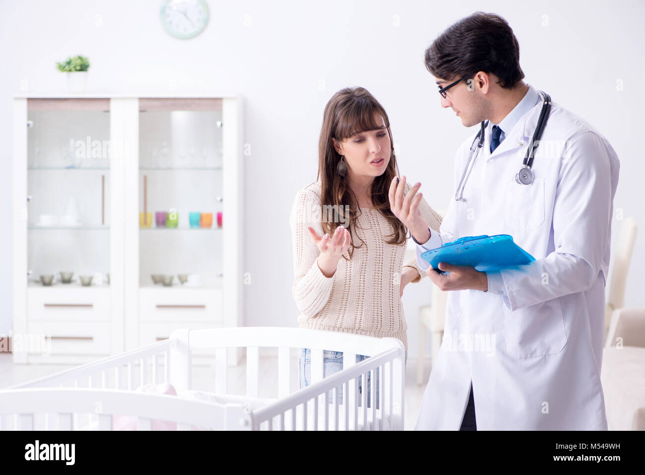 Doctor explaining to young mother Stock Photo - Alamy