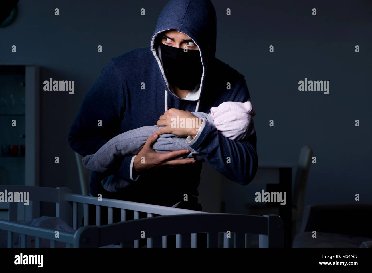 Criminal stealing baby in human child traficking concept Stock Photo ...