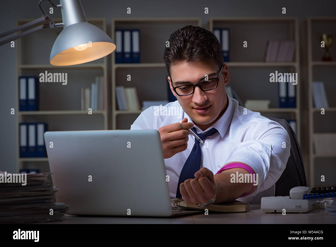 Businessman staying late in office for drugs Stock Photo - Alamy