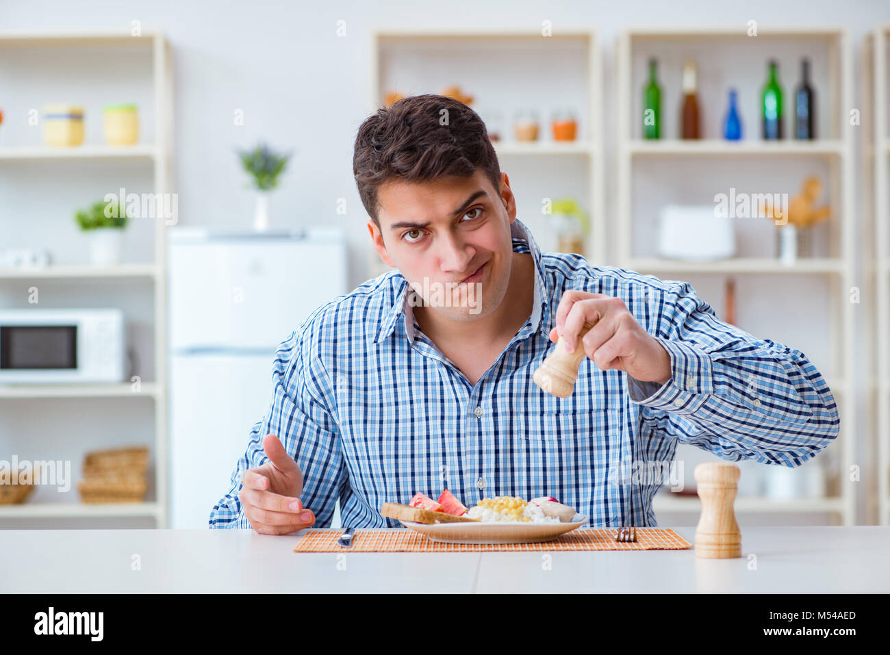 Young husband eating tasteless food at home for lunch Stock Photo - Alamy