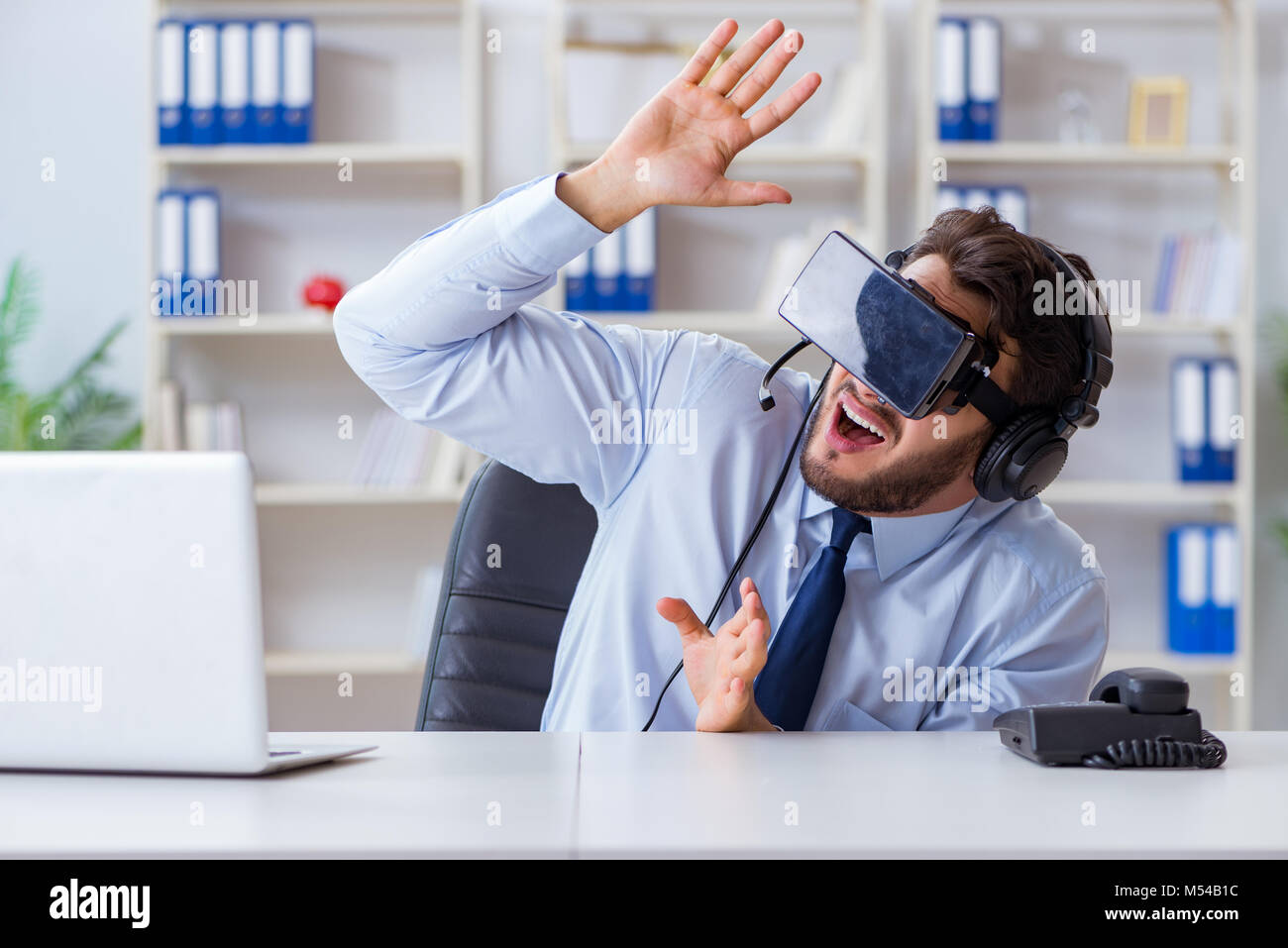 Businessman gamer in office playing games Stock Photo - Alamy