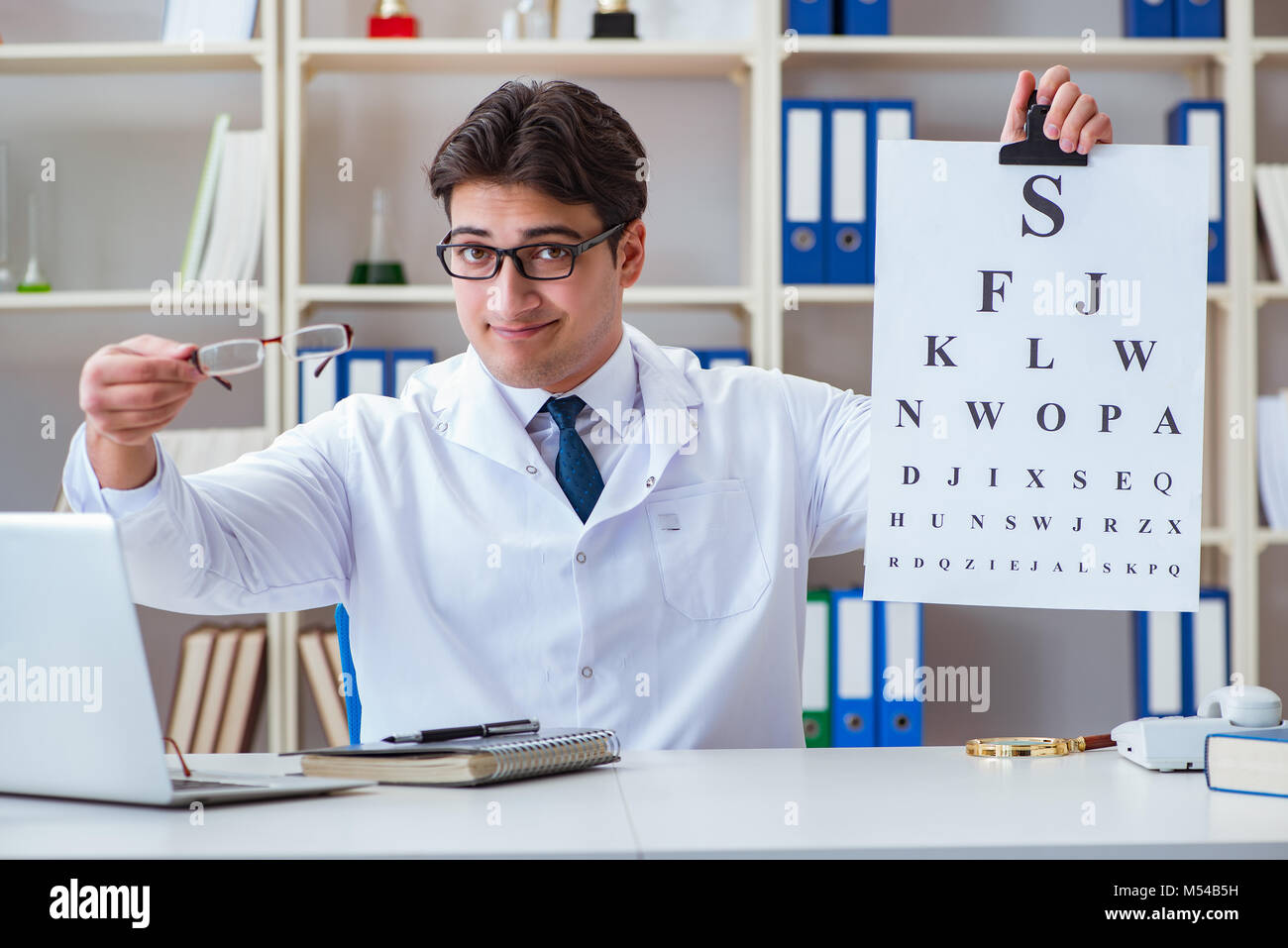 Doctor optician with letter chart conducting an eye test check Stock ...