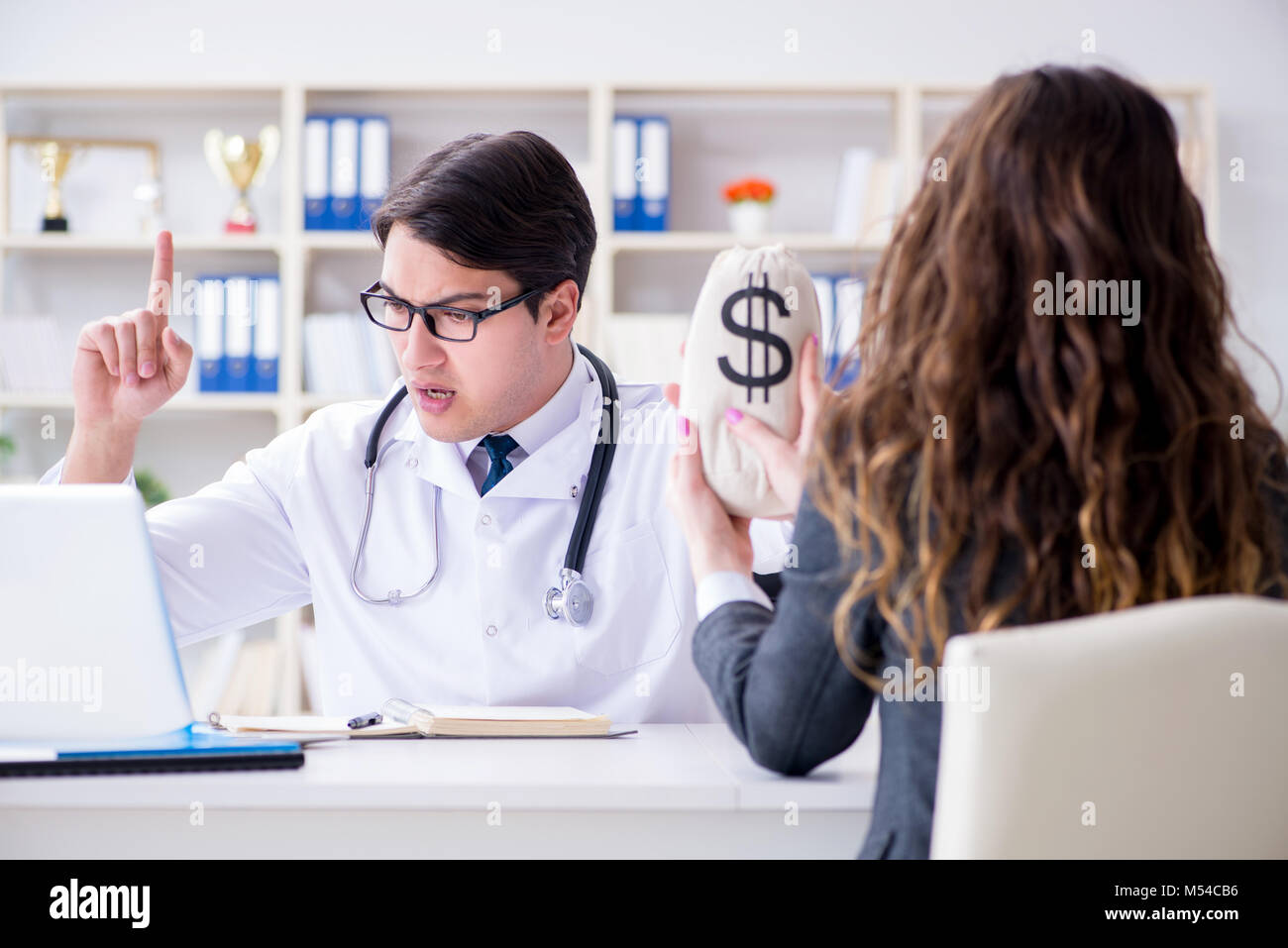 Young doctor in medical insurance fraud concept Stock Photo - Alamy
