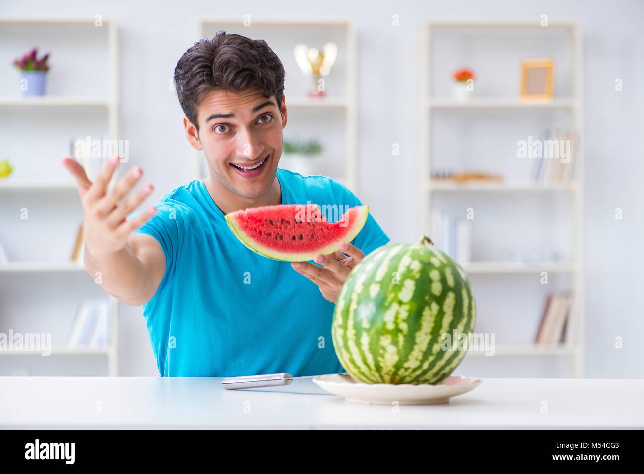 Man eating watermelon at home Stock Photo - Alamy