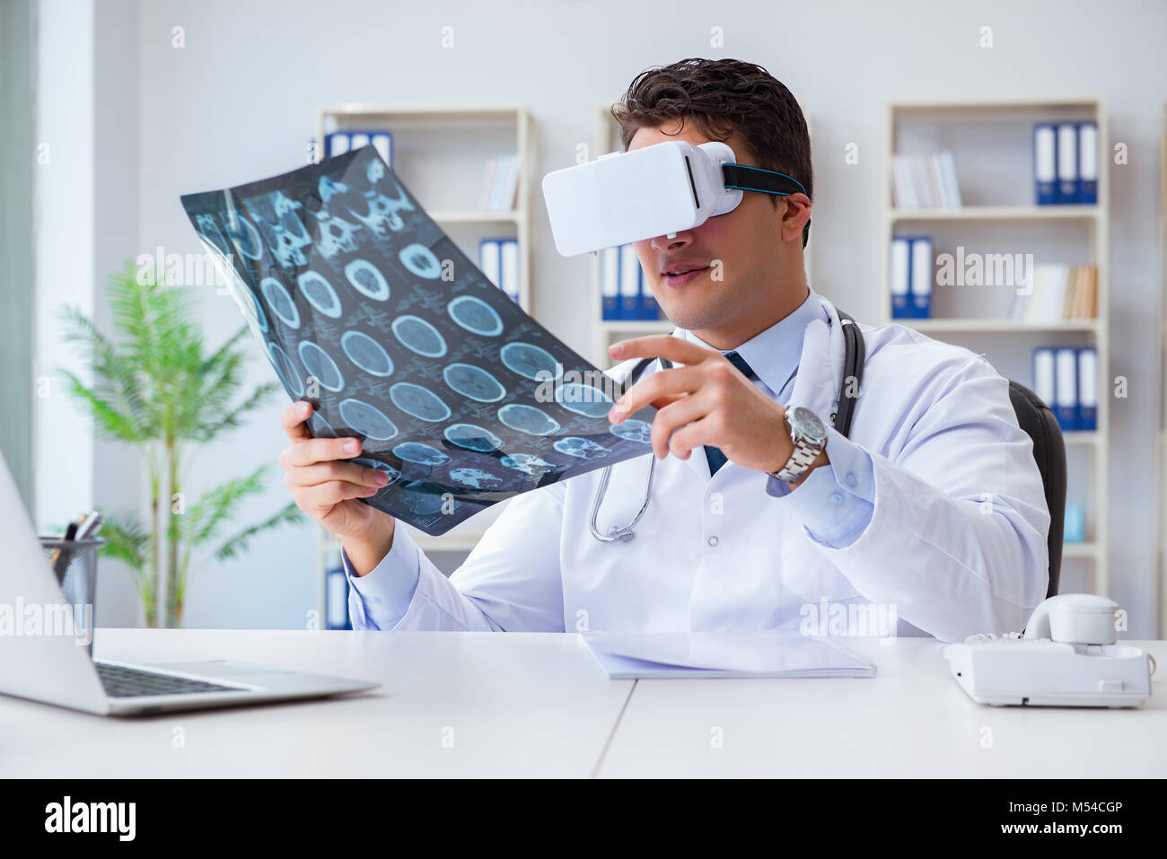 Young doctor looking at MRI scan through VR glasses Stock Photo - Alamy