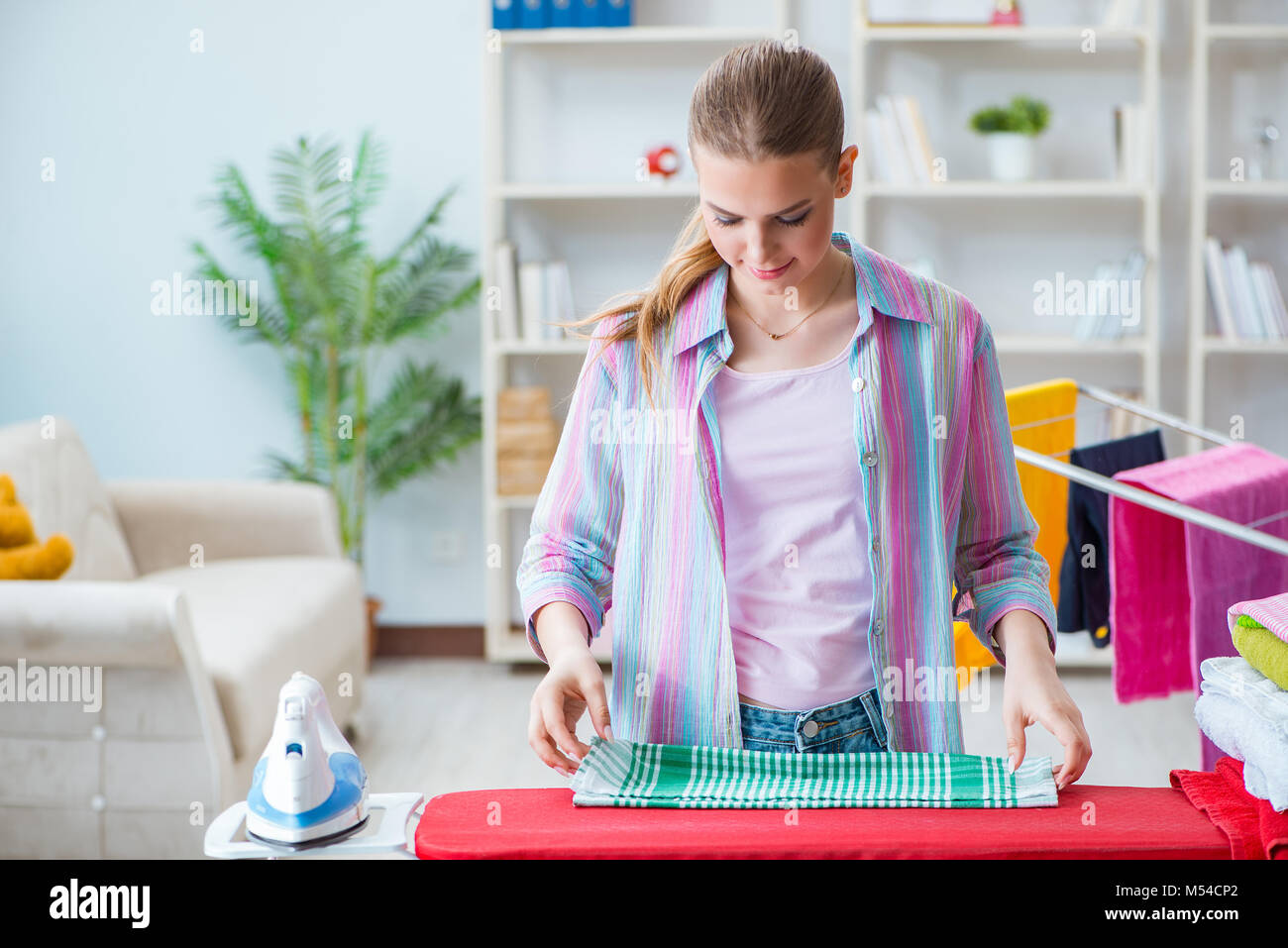 Happy housewife doing ironing at home Stock Photo - Alamy