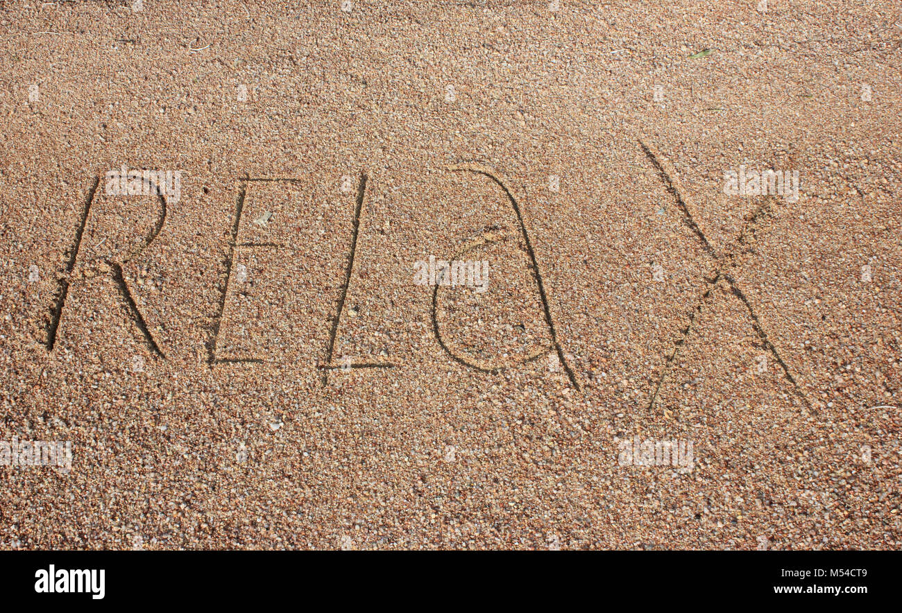 Relax text is written on sand Stock Photo - Alamy