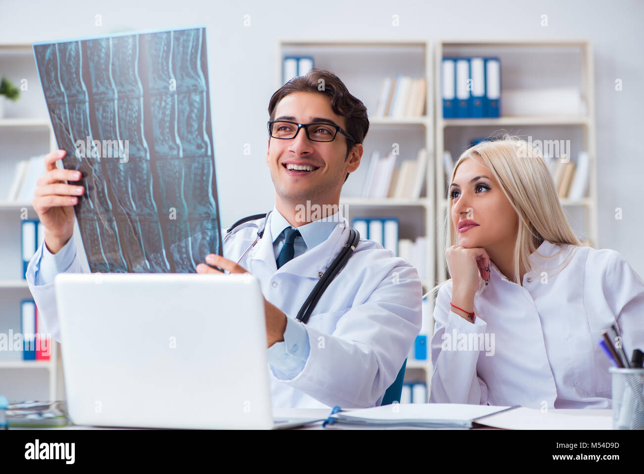 Two doctors examining x-ray images of patient for diagnosis Stock Photo ...